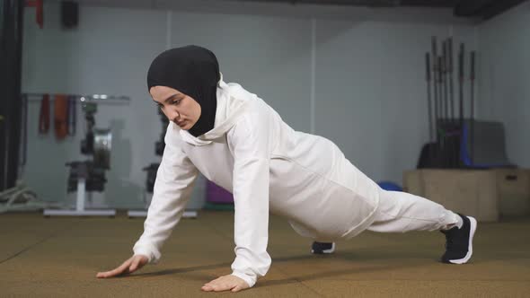 Muslim Woman in a Sports Hijab Does Exercises Planks Pushups in an ...