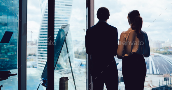 Faceless partners in front of office window Stock Photo by GaudiLab