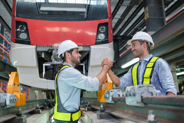 Railway Workers Celebrating Success at Train Depot Stock Photo by ...