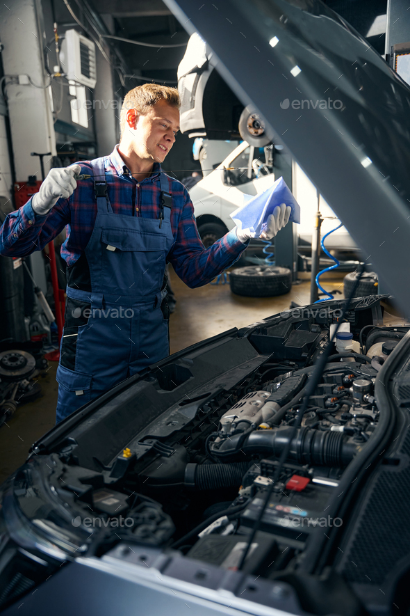 Male checking oil level in machine engine Stock Photo by svitlanah