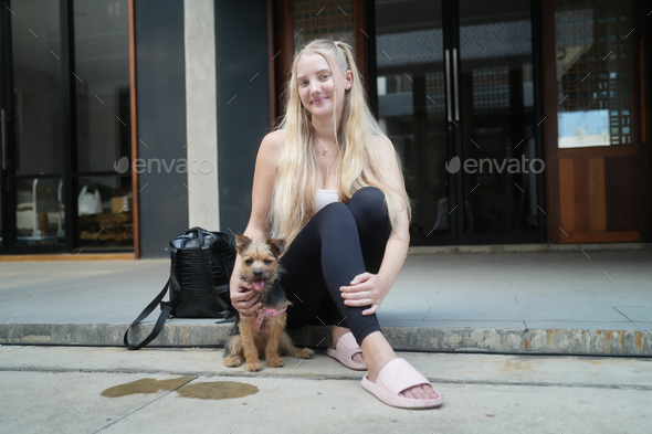 Pretty young female model, happy girl owner of a dog playing with a ...