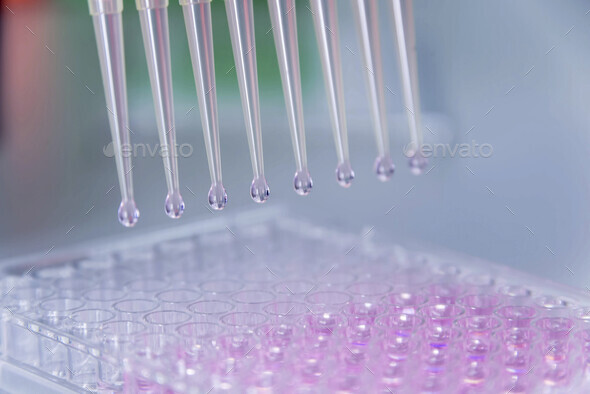 Cancer research laboratory, cells being dispensed using electronic ...