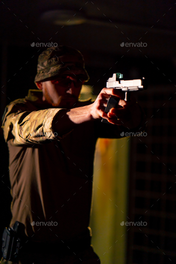 at a professional shooting range a military trainer reloading a pistol ...