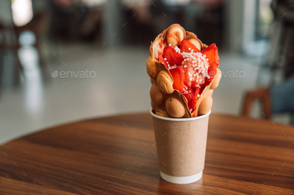 Bubble waffles in a cup with ice cream and strawberries Stock Photo by ...