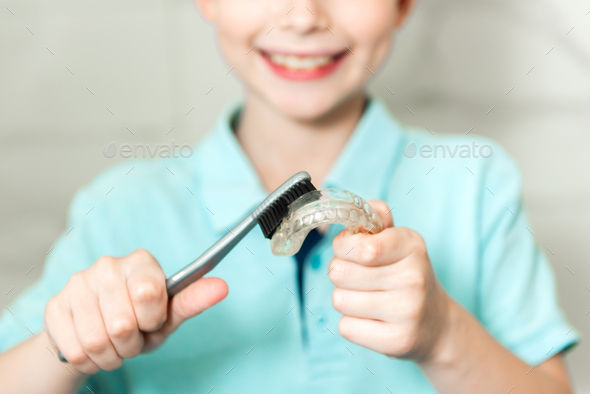 Cleaning tooth aligners. Washing and removing organic residues with a ...