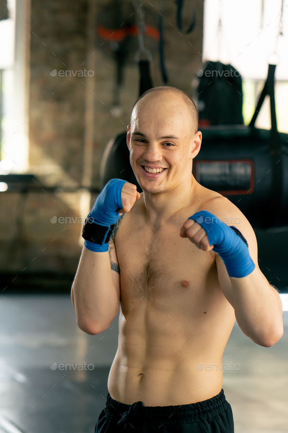 close-up in a boxing fight club bald young boxer with tattoos in blue ...