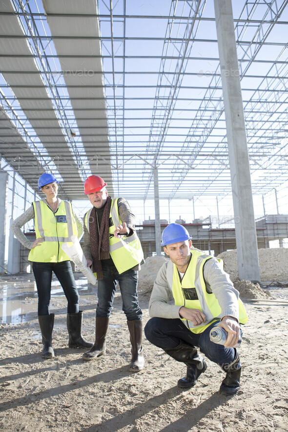 Surveyor and architects marking floor area with spray can on ...