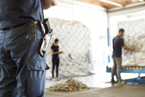 Security guard watching workers in air freight warehouse Stock Photo by ...