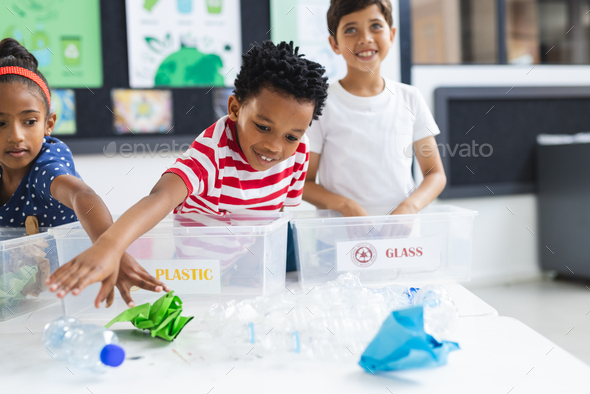 Students sorting recyclables into plastic and glass bins in bright ...