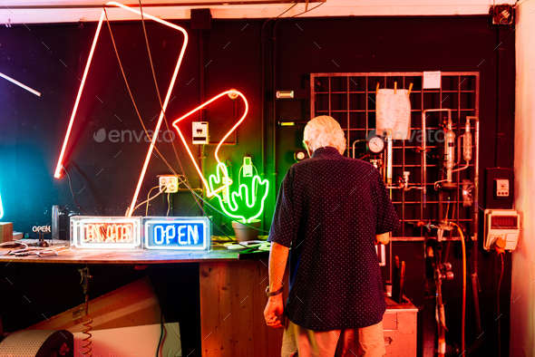 A Neon Sign Maker in His Workshop, Examining His Work Stock Photo by ...