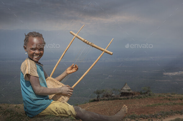 Young ethiopian girl playing a self made instrument, Lalibela, Ethiopia ...