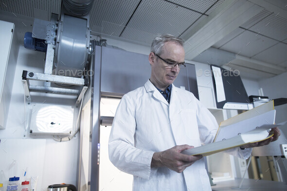 Male meteorologist reviewing data file from weather station laboratory ...