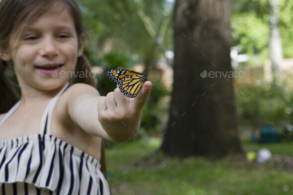 Girl holding monarch butterfly on finger smiling Stock Photo by Image ...