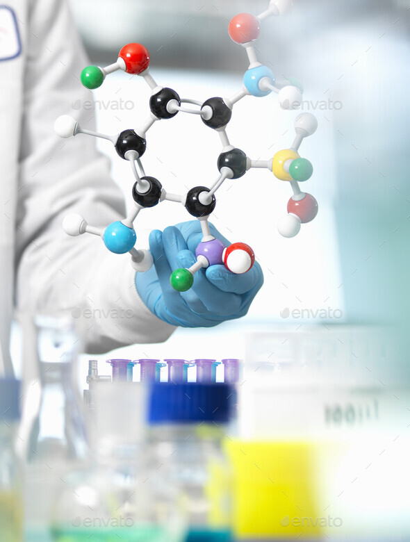Researcher using a molecular model to understand a chemical formula in ...