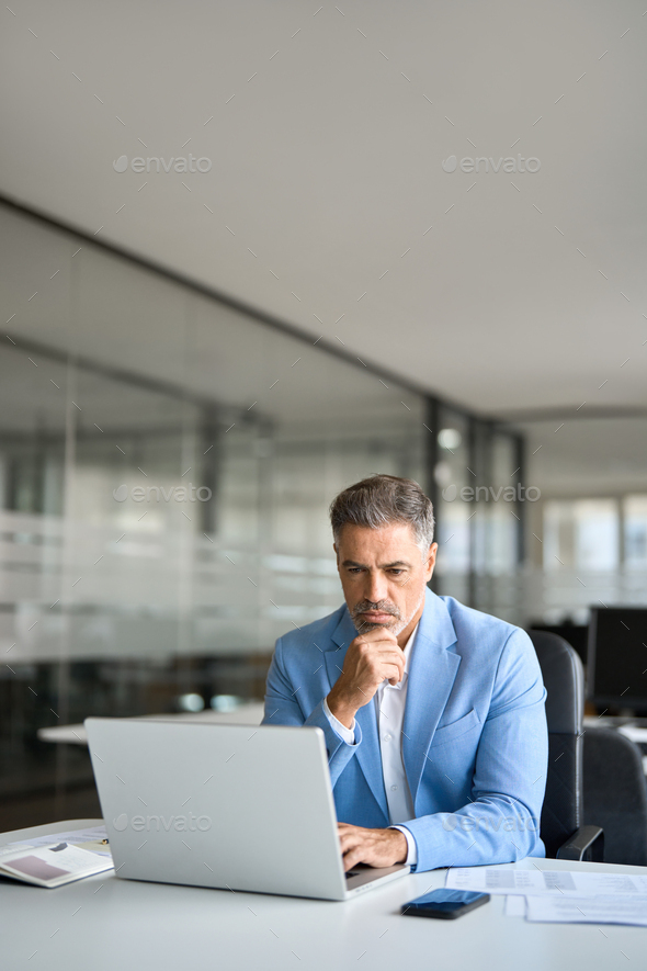 Busy middle aged professional business man using laptop in office ...