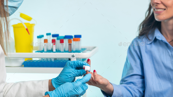 Nurse performs finger prick blood draw on patient for sample collection ...