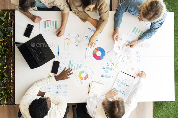 Business team analyzing financial data using charts and graphs during meeting, top view Stock ...