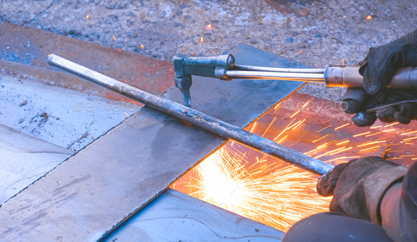 Welder hand is cutting black steel plate with acetylene gas welding ...