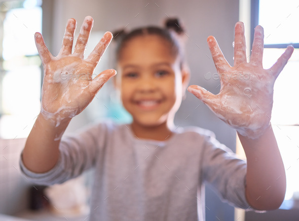 Little girl washing hands with water and soap in a bathroom. Happy kid ...