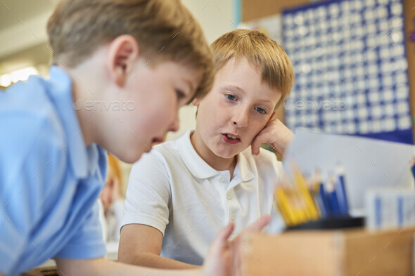 Curious kids engaged in a classroom activity. Stock Photo by Image-Source