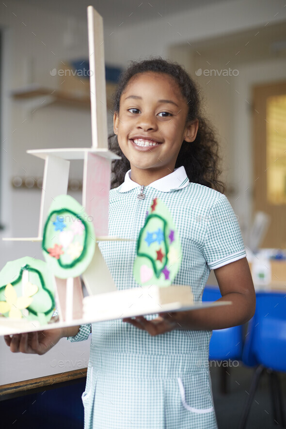 Young girl proudly showing her art project at school Stock Photo by ...