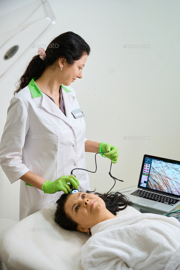 Trichologist performs a diagnostic procedure using a trichoscope Stock ...