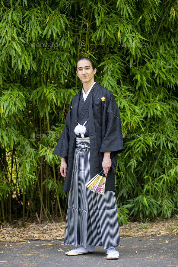 Man in traditional Japanese attire posing in front of bamboo Stock ...