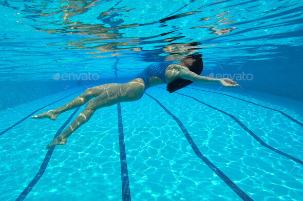 Swimmer gliding effortlessly through a clear blue pool Stock Photo by Image-Source