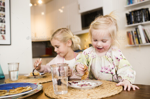 Two children enjoying a messy meal time together. Stock Photo by Image ...
