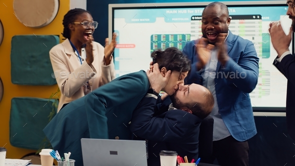 Pleased happy manager celebrating victory and kissing his employee ...