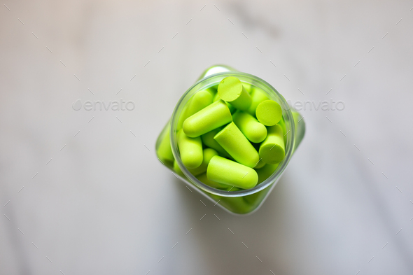 green ear plugs noise reduction sleep quiet jar white background ...