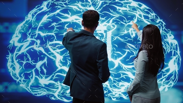 Coworkers building AI machine learning algorithms in futuristic workspace Stock Photo by DC_Studio