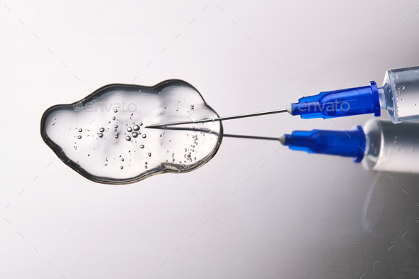 A drop of medicine flowing from a syringe with a needle. Stock Photo by ...