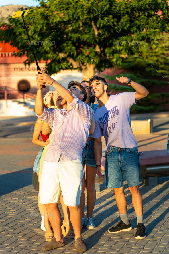 Gen Z friends sitting together outdoors, posing and smiling Stock Photo ...