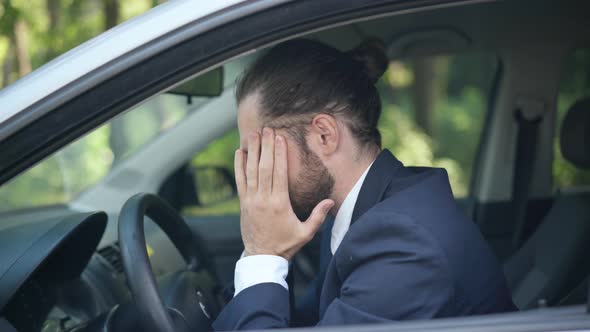 Side View Portrait of Young Stressed Caucasian Man in Suit Sitting on ...