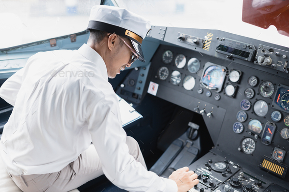 Portrait of a trained airplane captain in uniform preparing to fly in a ...