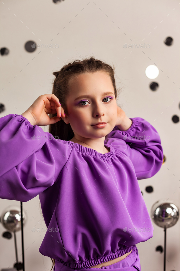 Portrait of positive kid girl model 8 year old in purple attire posing ...