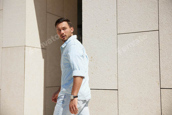 Surprised man turning around a corner, looking back with a startled ...