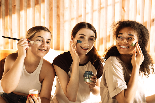 Lovely teenagers of different races and nationalities apply cosmetic ...