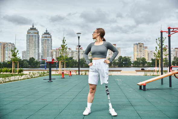Empowered young woman with prosthetic leg enjoys outdoor workout in ...