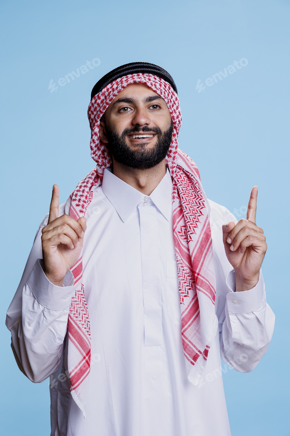 Arab man dressed in thobe pointing up Stock Photo by DC_Studio | PhotoDune