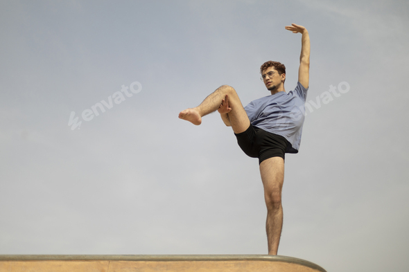 Ballet dancer performs a blend of classical and modern poses on an ...