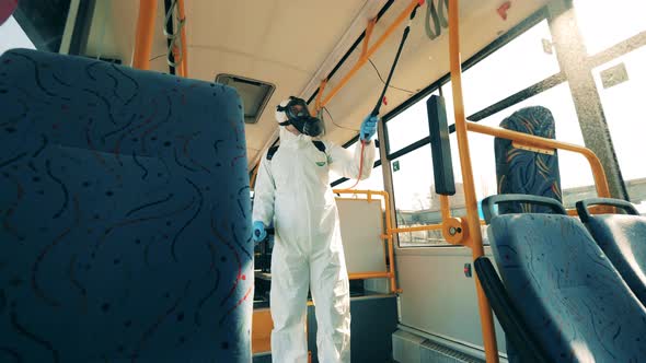 A Person in a Splash Suit Is Sanitizing Bus From Inside, Stock Footage