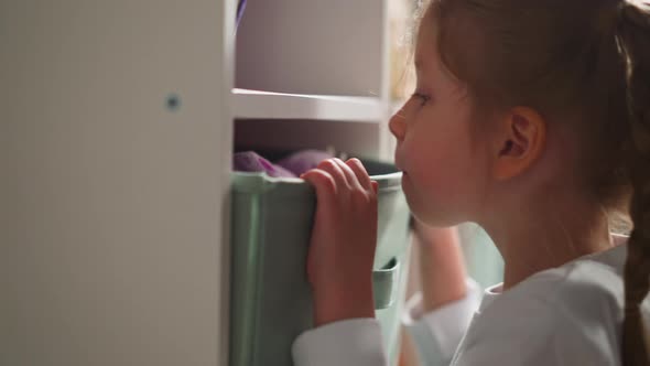Little Girl Looks Inside Large Containers on Wooden Rack, Stock Footage