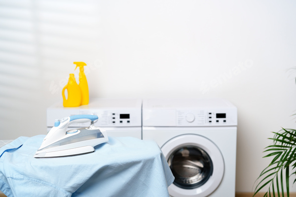 Modern Laundry Room With White Washing Machines, Ironing Board, and ...