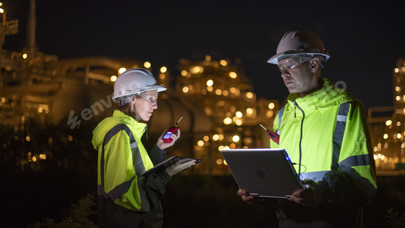 Engineers wear uniform and helmet stand in holding tablet computer ...