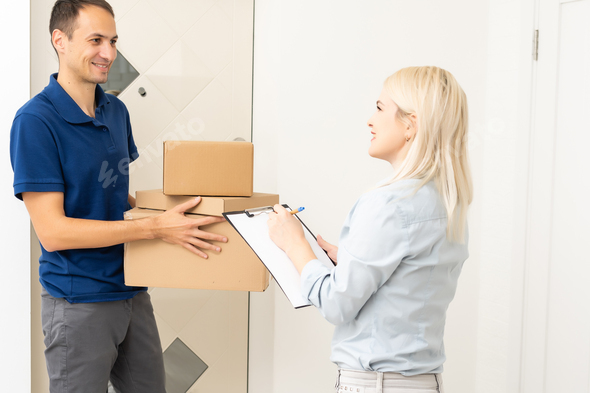 woman receiving boxes from postman at the door in home delivery concept ...