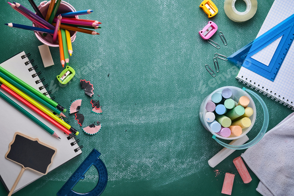 School supplies and black table lamp on green board. Concept back to ...