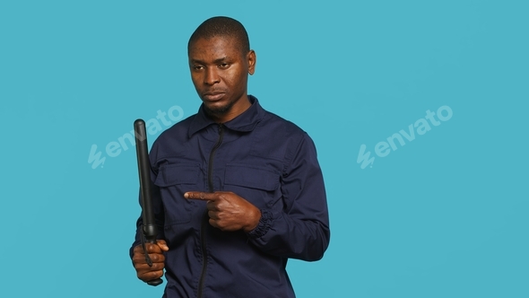 Portrait of bodyguard pointing finger towards truncheon Stock Photo by ...