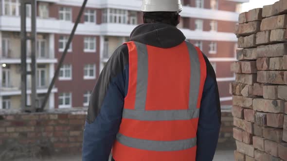 The construction worker is walking along the construction site., Stock ...